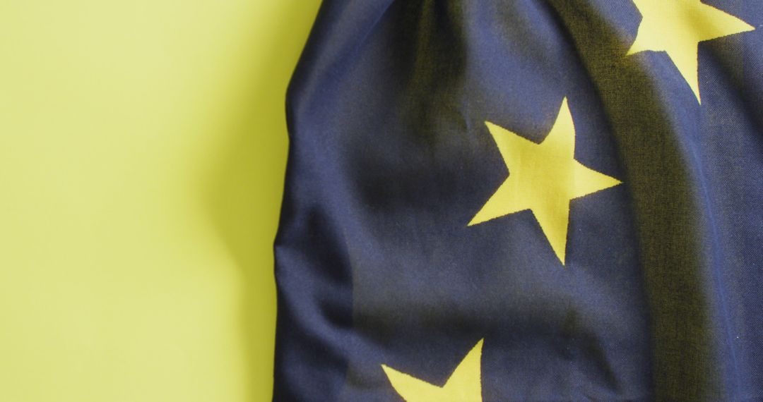 Half-Visible European Union Flag on Bright Yellow Background