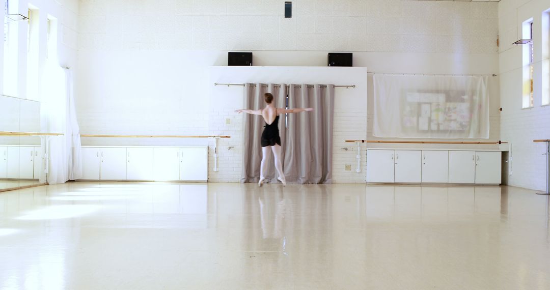 Ballerina Dancing Elegantly in Sunlit Dance Studio