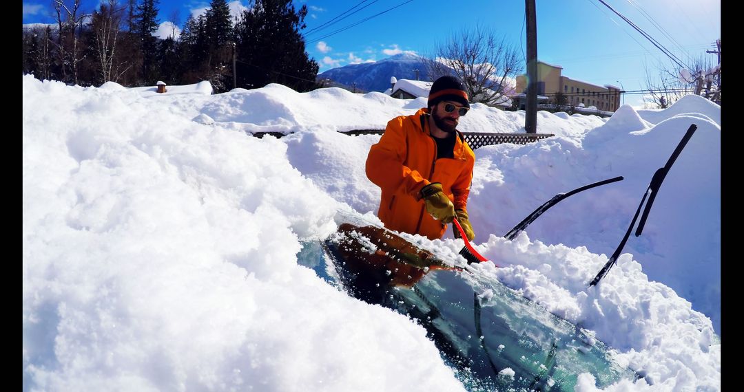 Man Clearing Snow from Car Windshield in Winter Day
