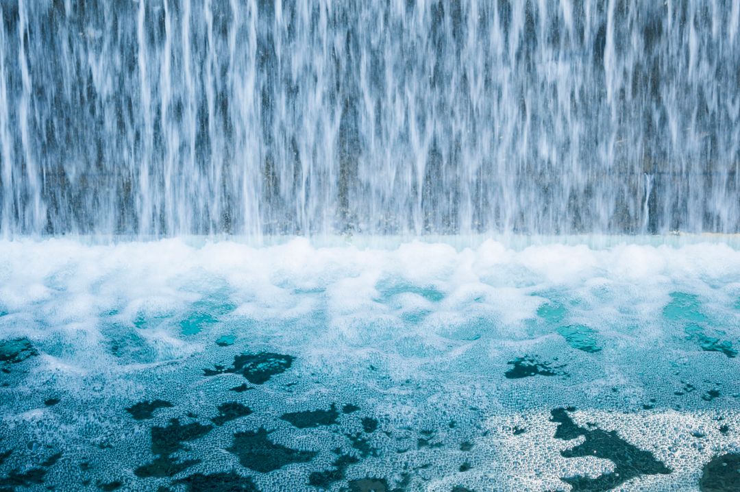 Cascading waterfall creating turquoise water with white bubbles